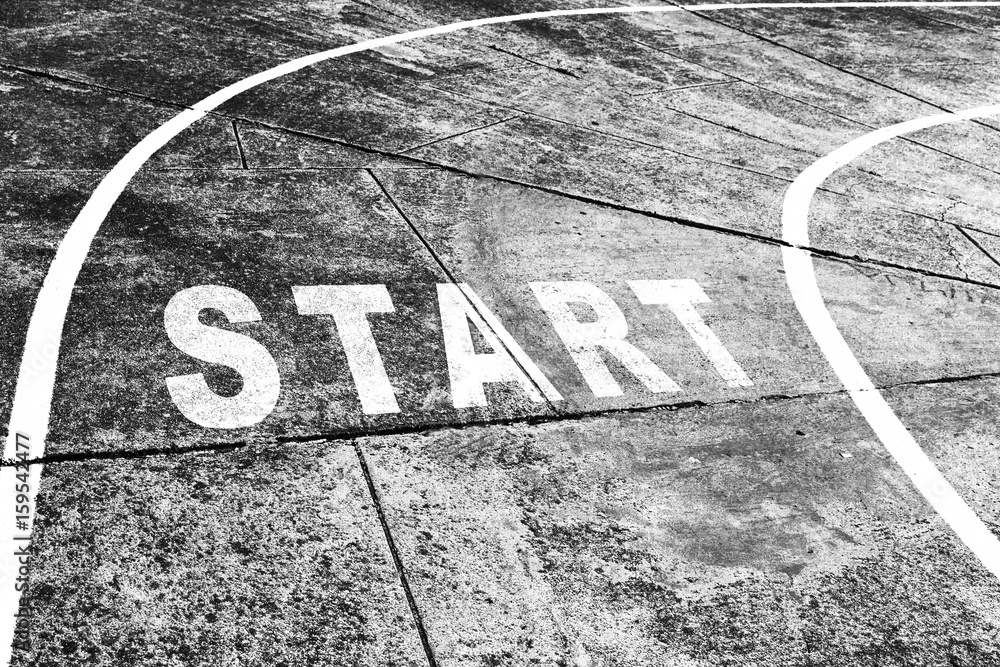 Grunge textured curve road sign with start line message on the floor ...