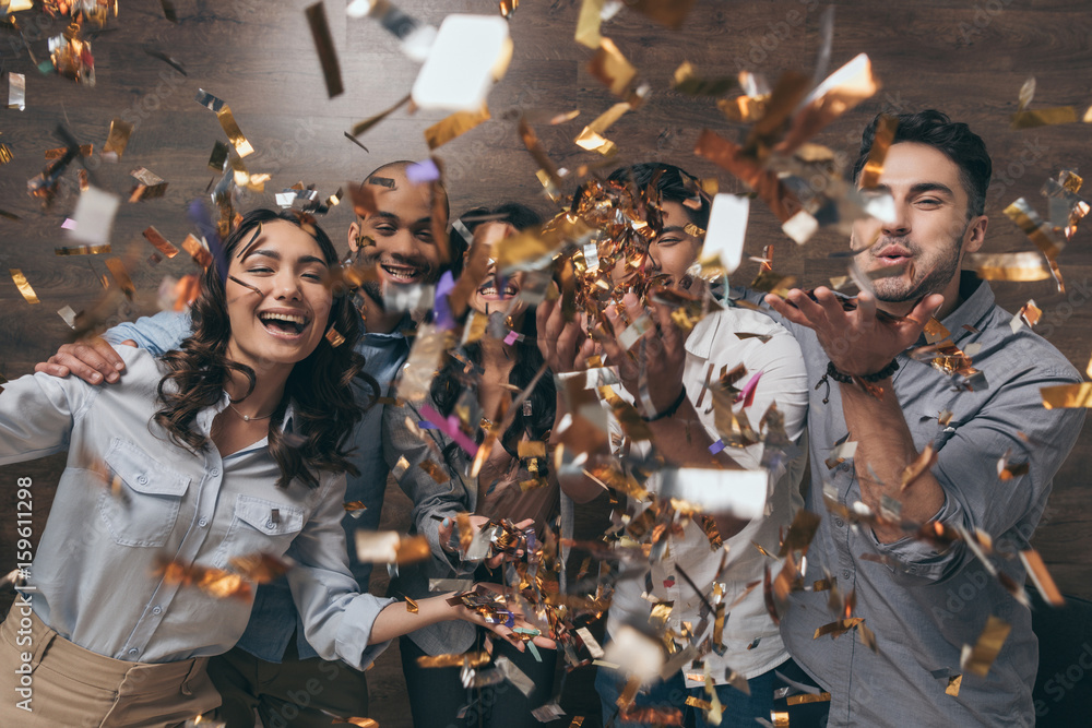Multiethnic group of cheerful young people standing together and ...