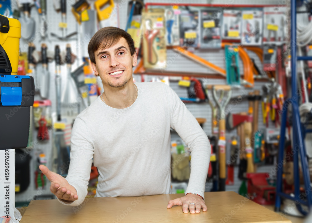 smiling young salesman in apron with tools Stock-Foto | Adobe Stock