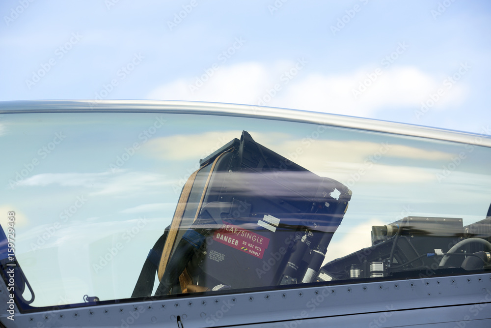 Cockpit of a modern tactical jet fighter. Seat with warning signs about ...