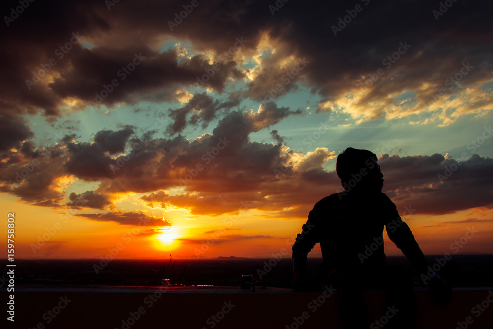 Silhouette of a man into sunset sky clouds Stock Photo | Adobe Stock