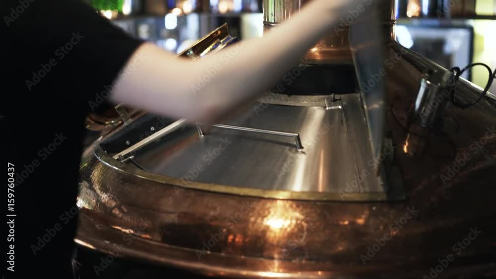 Close up of a hand of a brewery worker closing a lid of a beer cask at ...