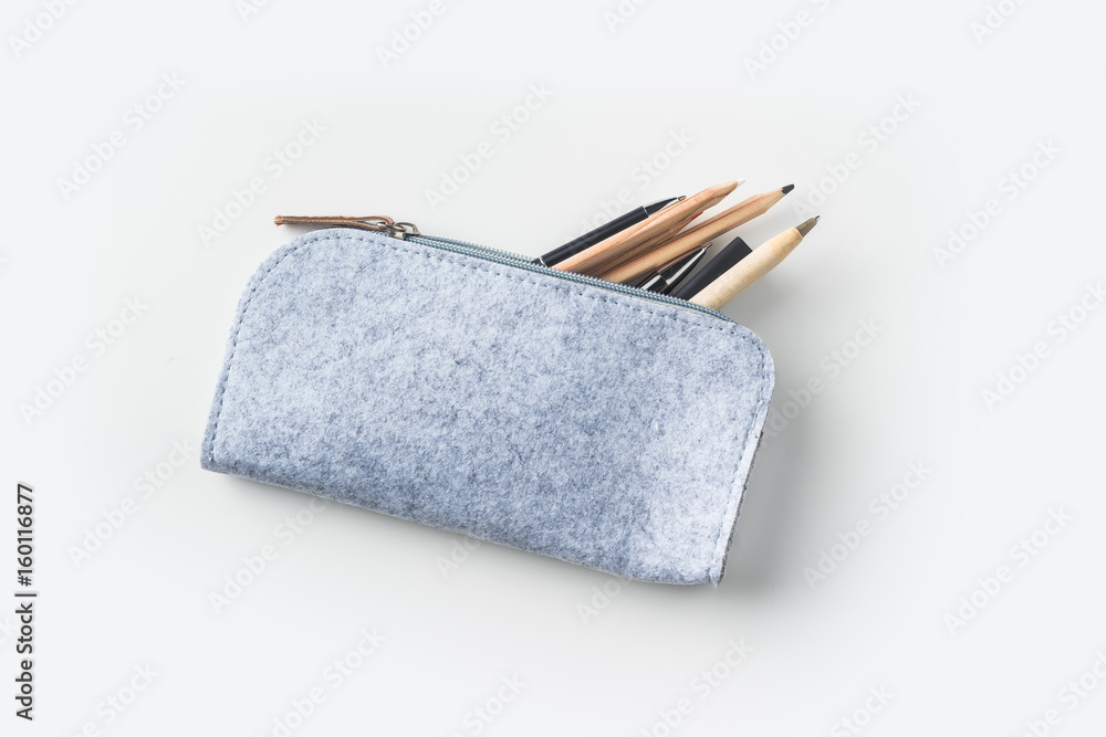 Top view of grey fabric pencil case with lot of pens on white ...