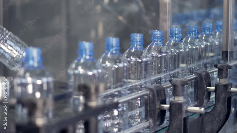 Plastic bottles transporting system at a modern industrial conveyor ...
