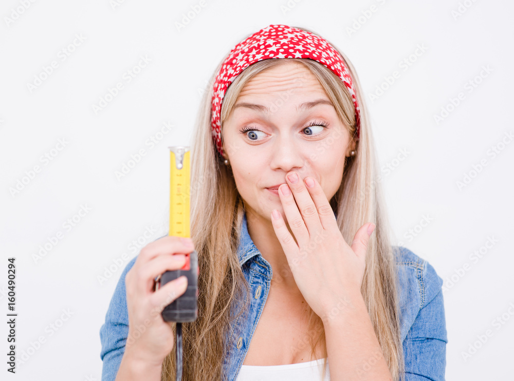 Beautiful young woman is laughing at the size shown on the measuring ...