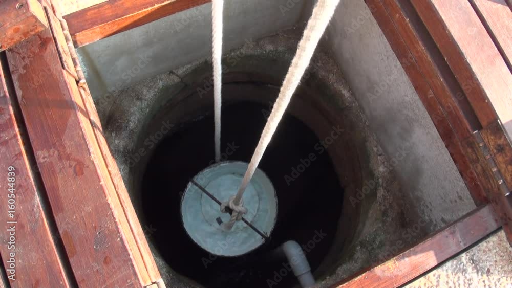 A bucket of water is entering a well to draw another with the help of a ...