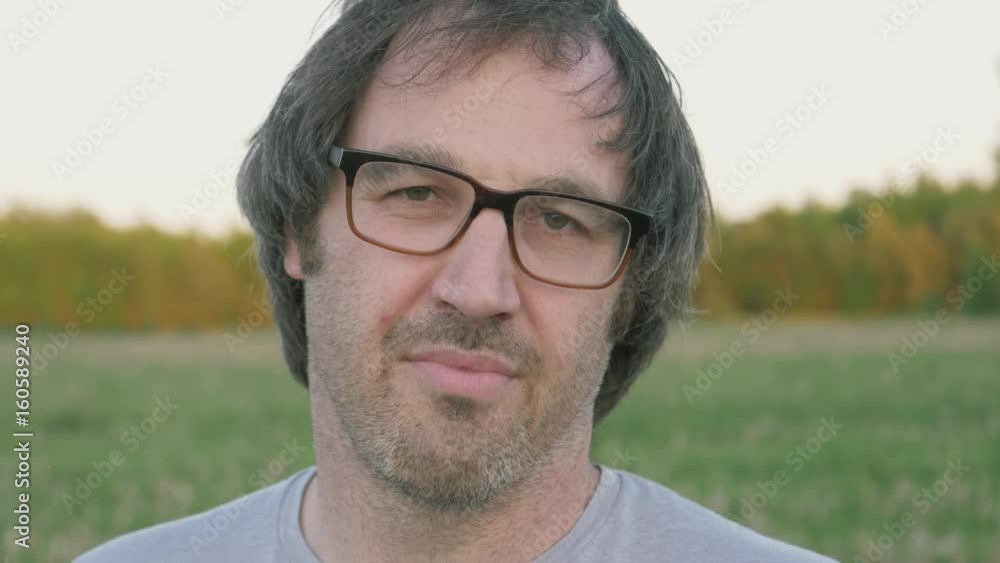 Man looking directly into the camera lens. Agricultural field in the ...