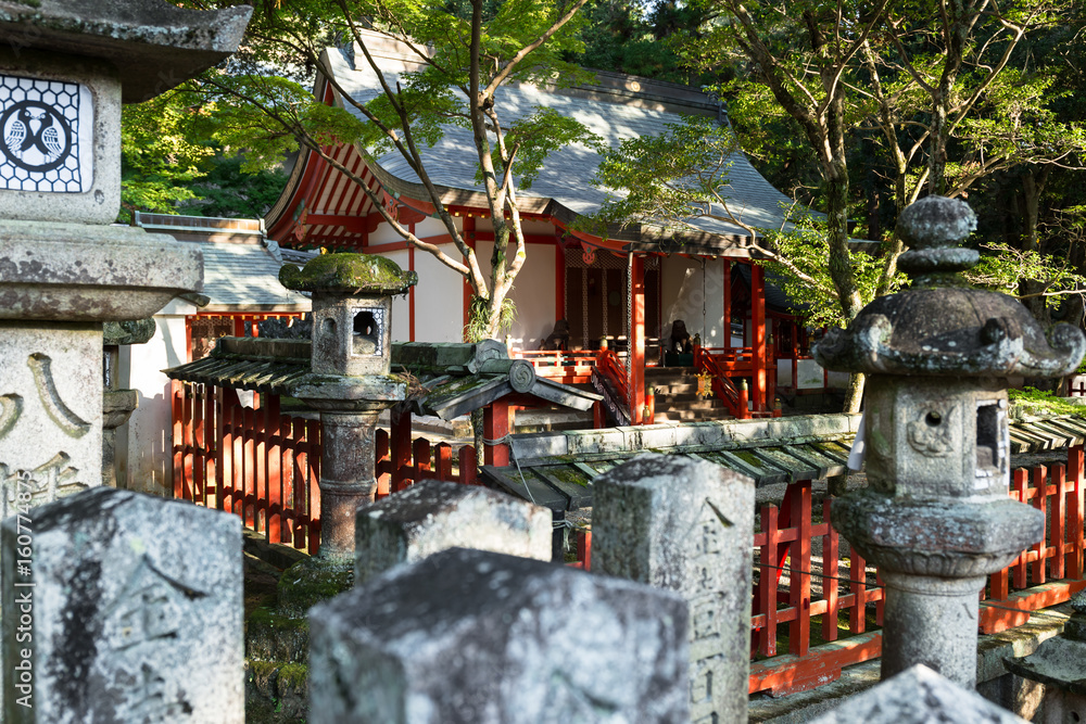 Cemetery with tombstones and the side of traditional wooden Shinto ...