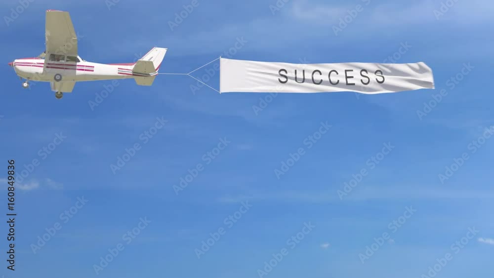 Small propeller airplane towing banner with SUCCESS caption in the sky ...