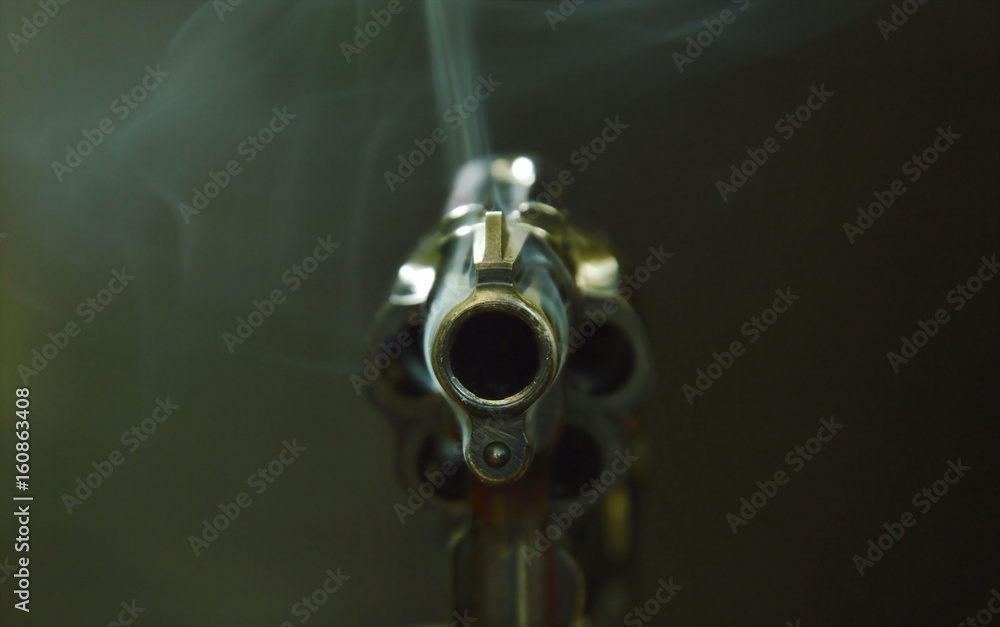 revolver gun muzzle with smoke floating in the air after shoot on black ...