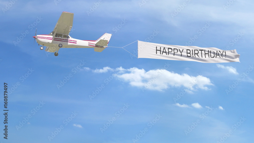 Small propeller airplane towing banner with HAPPY BIRTHDAY caption in ...