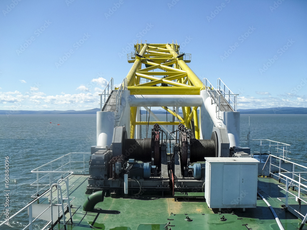 Laying of pipes with pipe-laying barge crane near the shore. Descent of ...