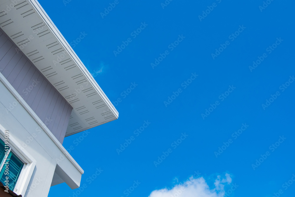 White eaves with ceiling and roof of modern house against blue sky ...
