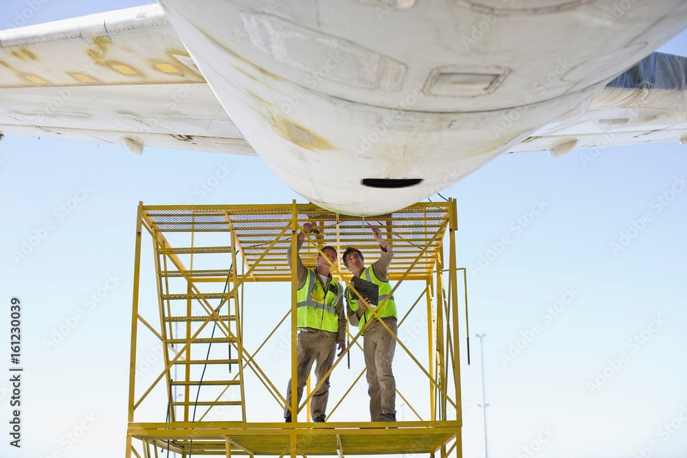 Aircraft workers repairing airplane Stock Photo | Adobe Stock