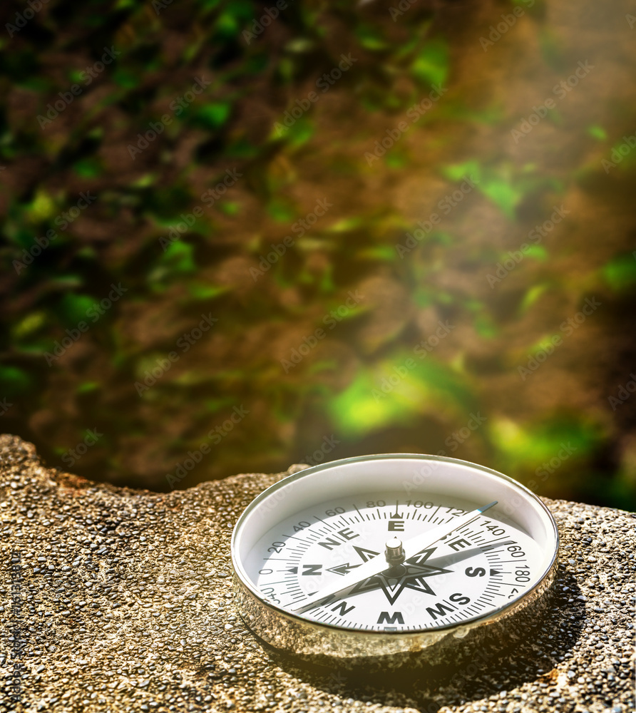 compass on small gravel stone background in sun light, changing ...