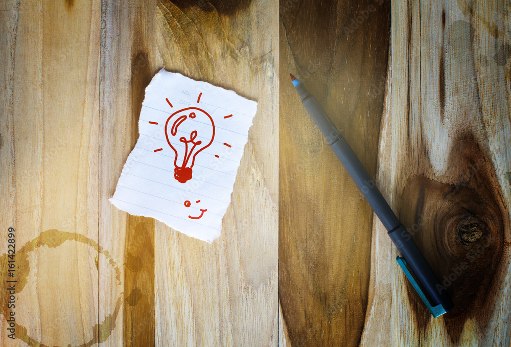 drawing a light bulb on paper. Stock Photo | Adobe Stock