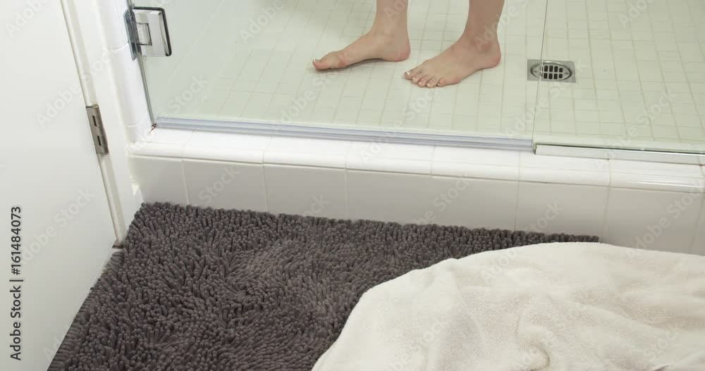 Woman drops her towel as she enters shower. Stock Video | Adobe Stock