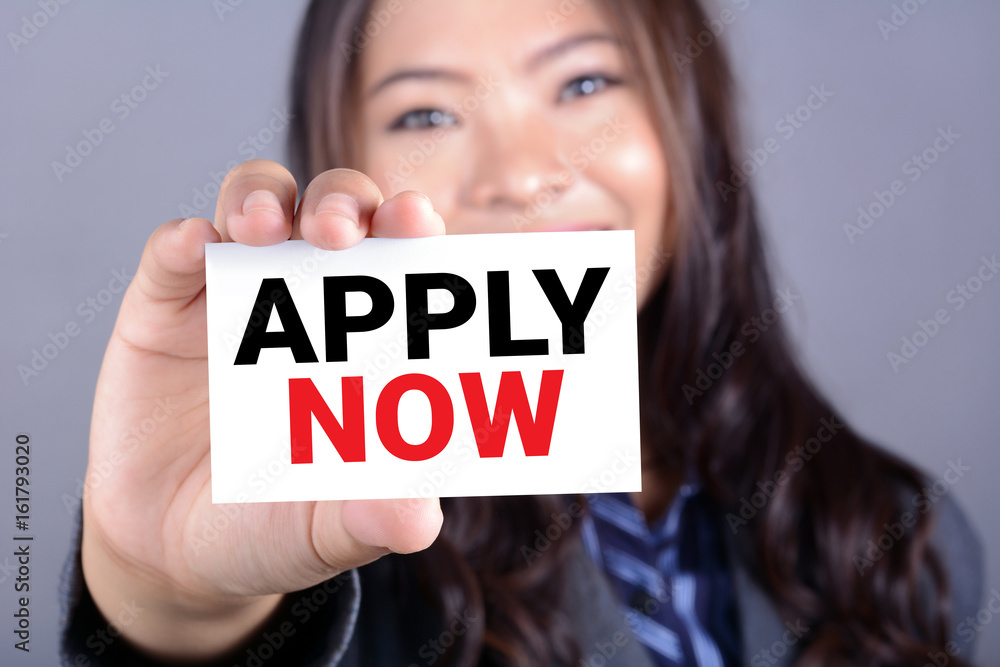 APPLY NOW, message on the card shown by a woman foto de Stock | Adobe Stock
