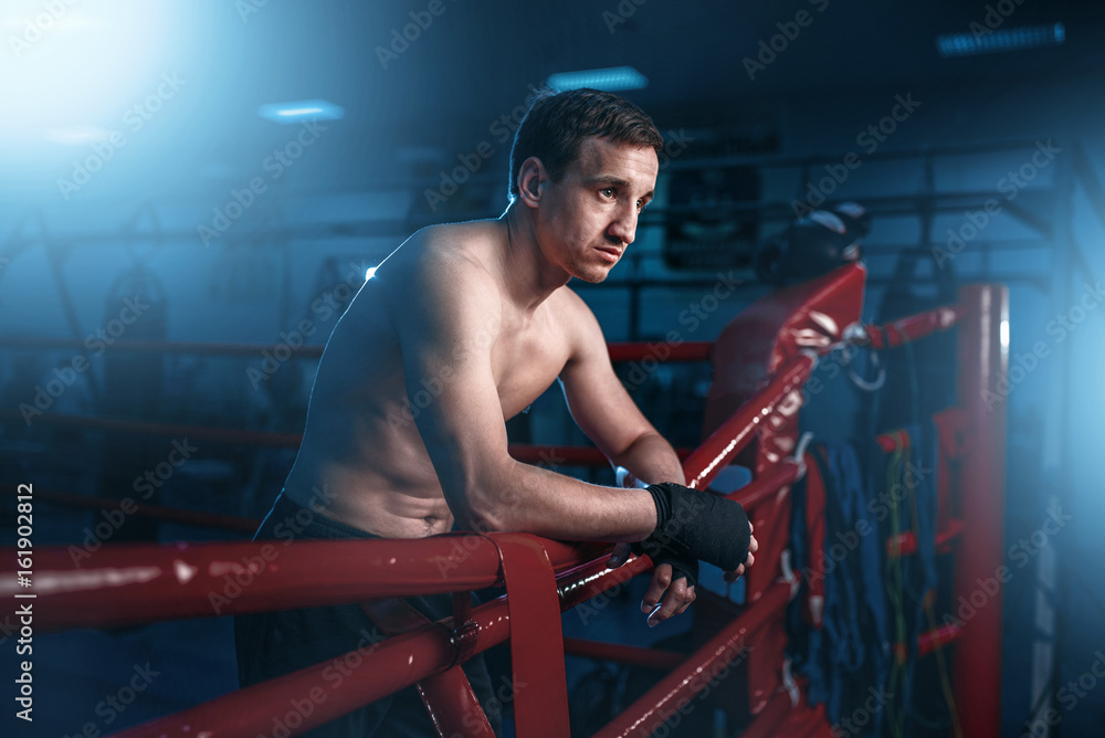 Boxer in black handwraps poses on ring ropes Stock Photo | Adobe Stock
