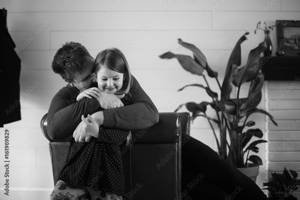 Father and daughter cuddling in living room Stock Photo | Adobe Stock