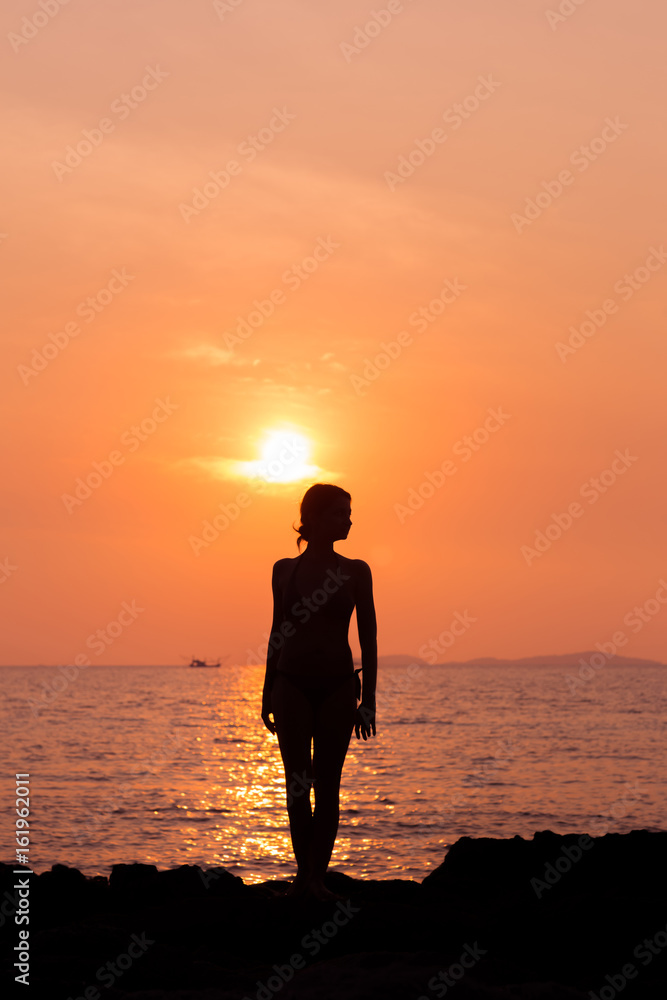 Standing woman silhouette on sunset sea background, back lit Stock ...