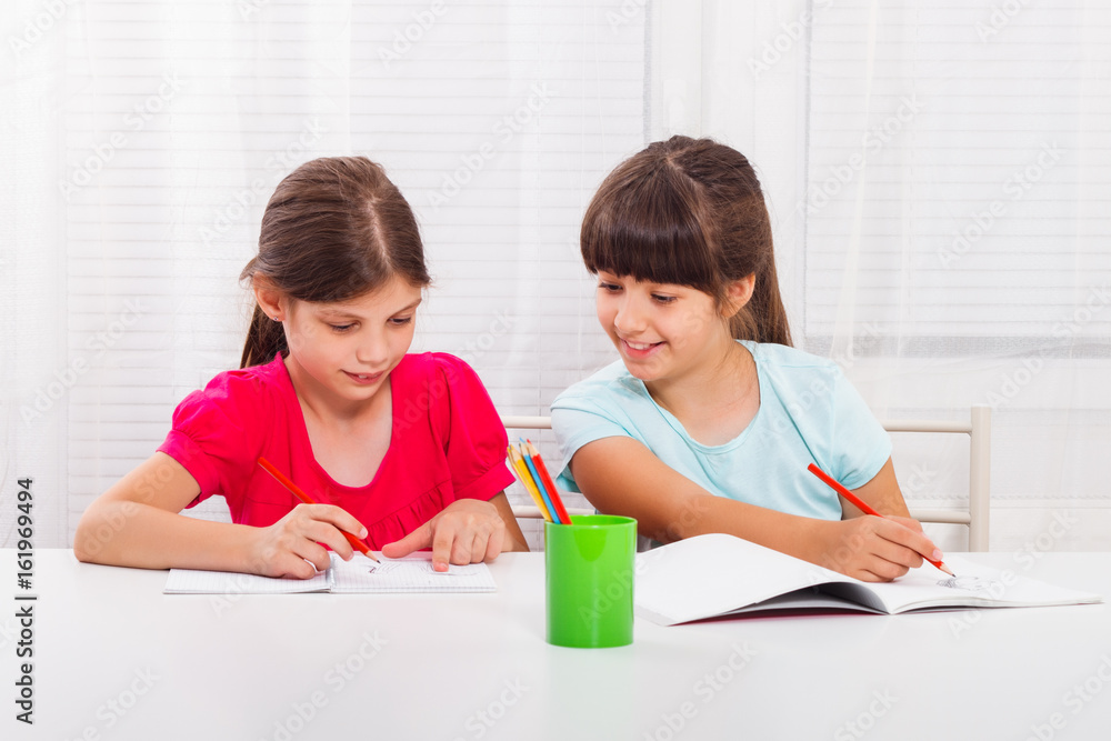 Cute little girls are helping each other with homework. Stock Photo ...