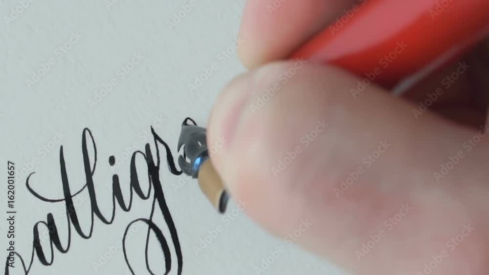 Calligrapher writing a word Calligraphy with point nib pen and black ...