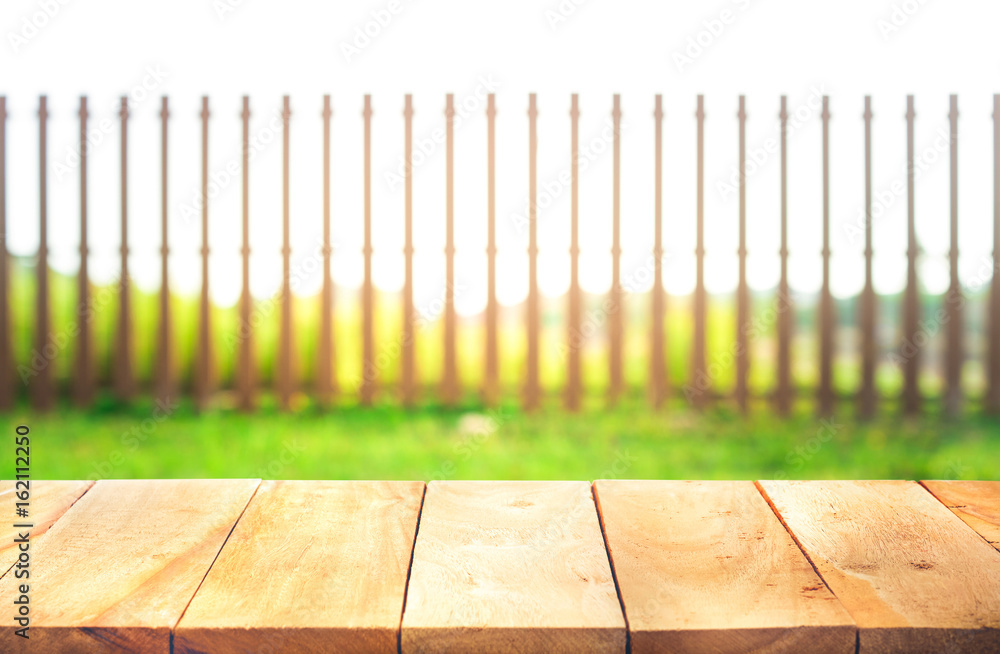 Wood table top with fence and grass in garden background.For create ...