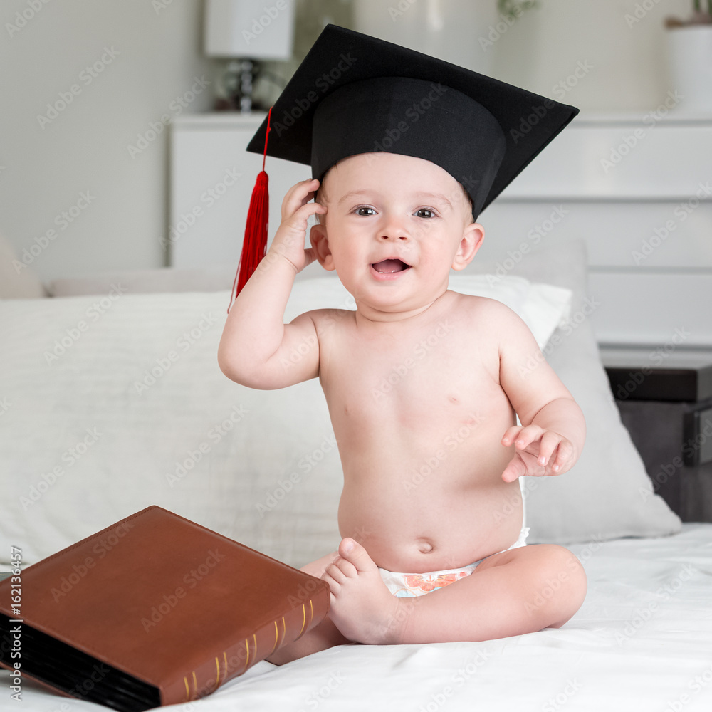 Funny image of naked baby in diapers and graduation cap sitting on sofa ...