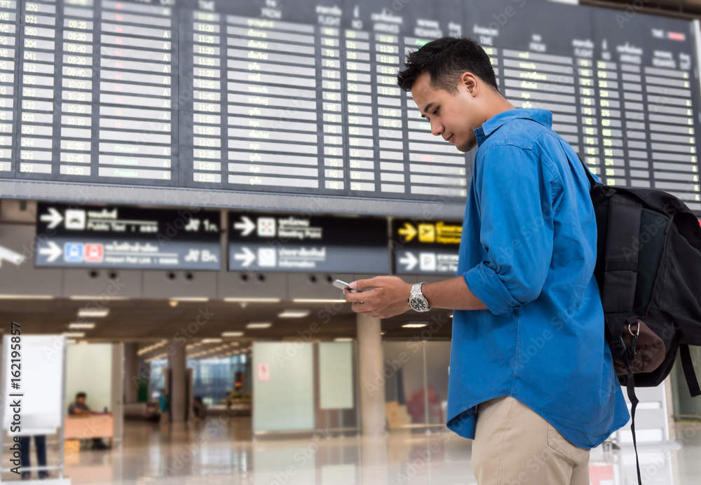 Asian traveler using the smart mobile phone for check-in at the flight ...