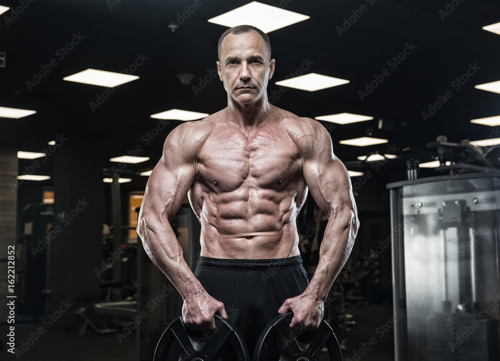 Foto de Brutal bodybuilder athletic man with six pack, perfect abs, shoulders, biceps, triceps ...