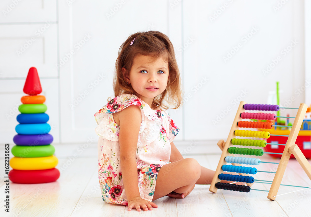 cute little baby girl playing with wooden toy on the floor Stock Photo ...