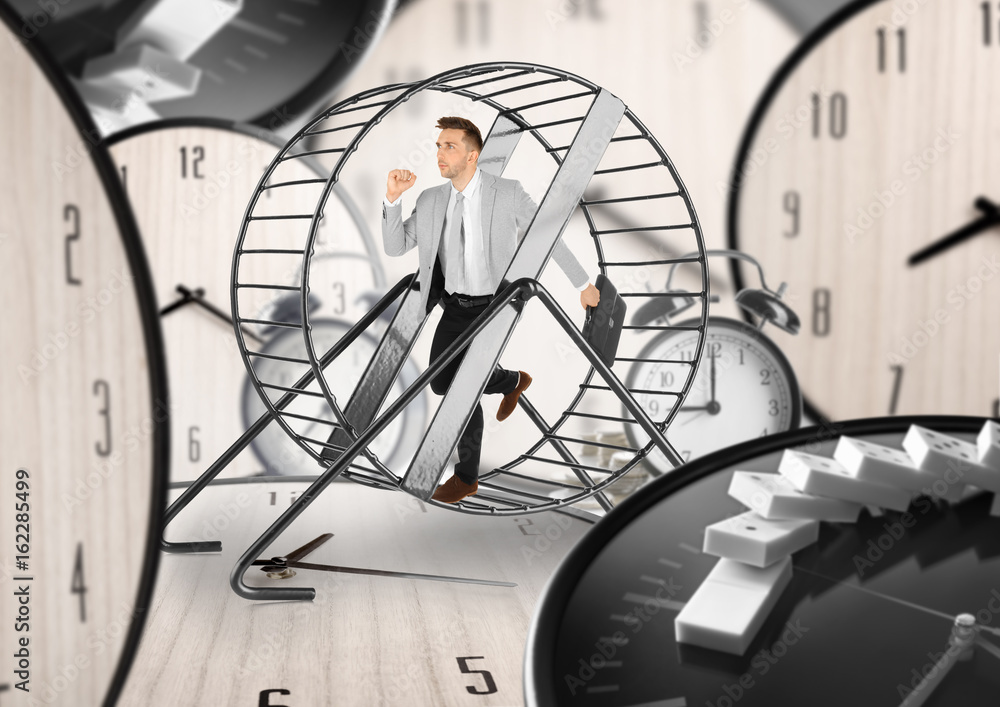 Young man running in wheel and clocks on background. Business rat race ...
