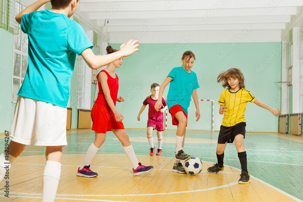 Children playing football in school sports hall Stock Photo | Adobe Stock