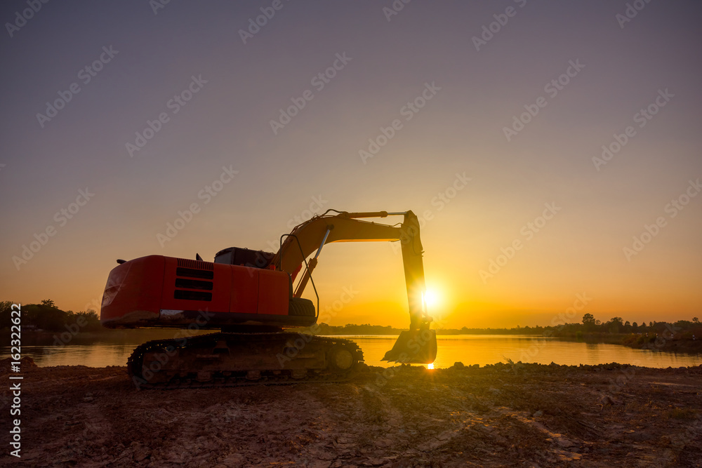 Backhoe was digging earthmoving work at construction site on sunset ...