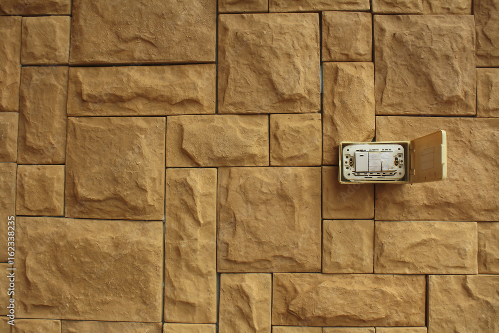 Foto de Old Power switch on the walls of the orange stone stacked ...