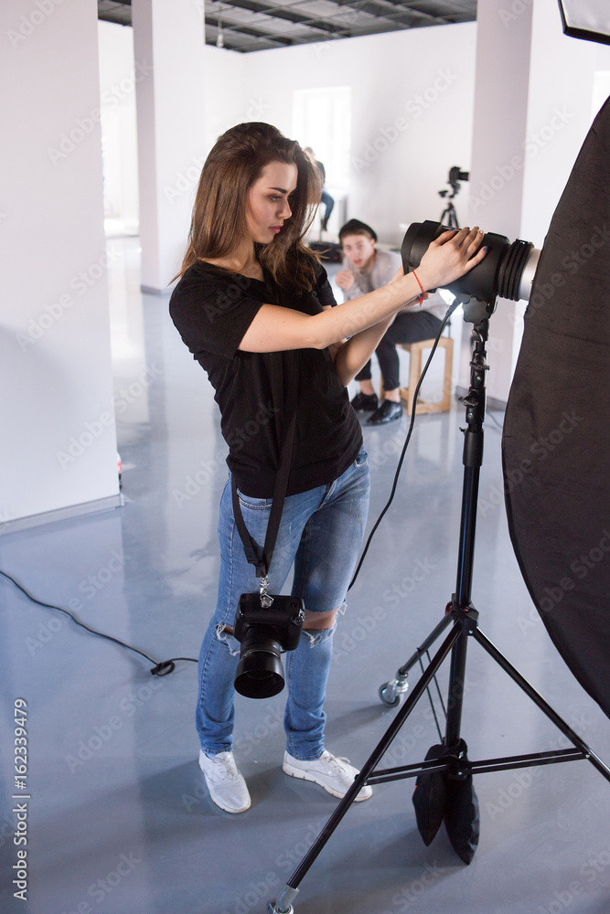 Young female photographer work in studio. Beautiful woman with camera ...