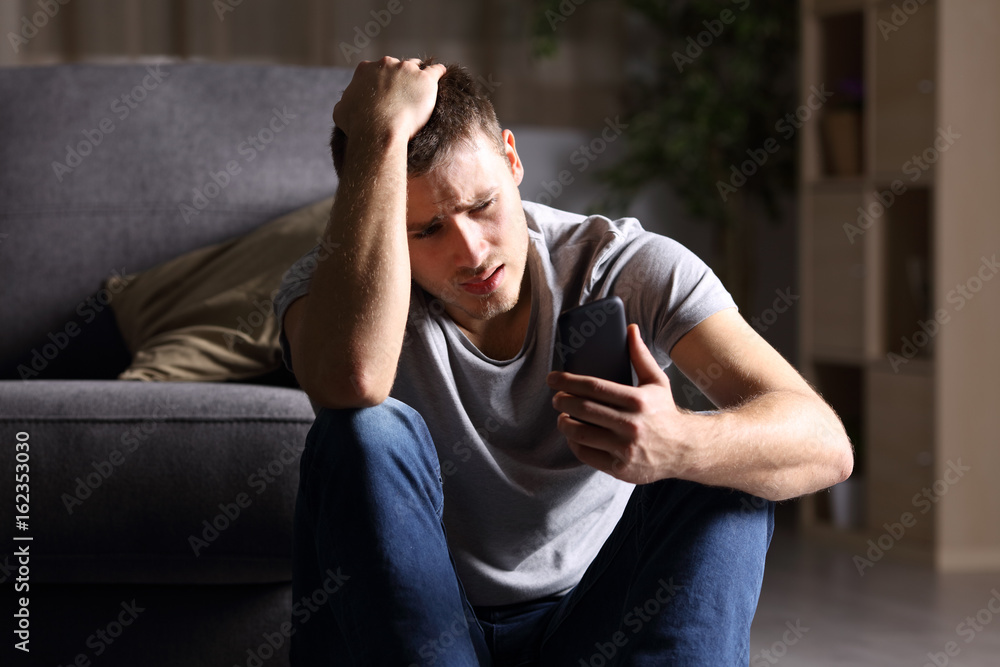 Sad man checking mobile phone Stock Photo | Adobe Stock