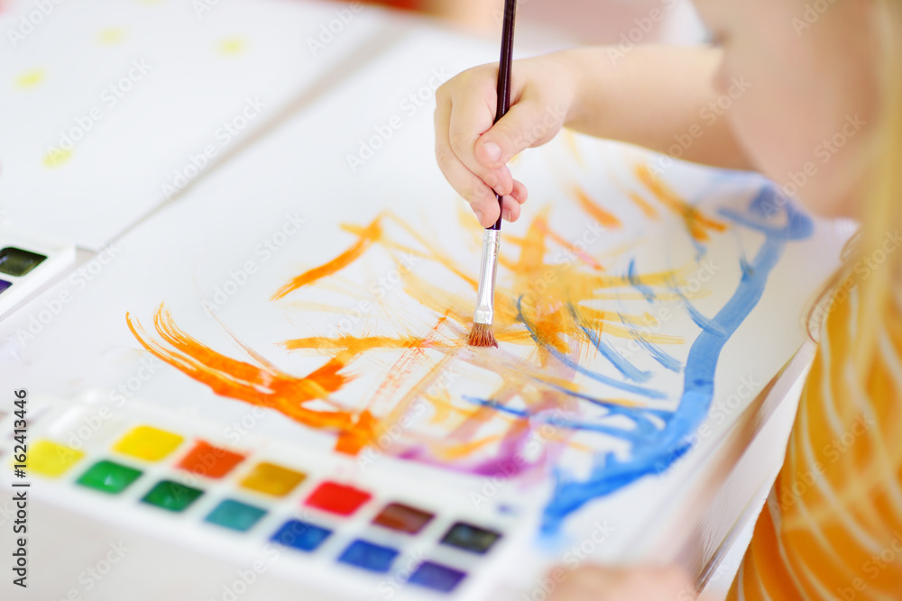 Cute little girl drawing with colorful paints at a daycare. Creative ...
