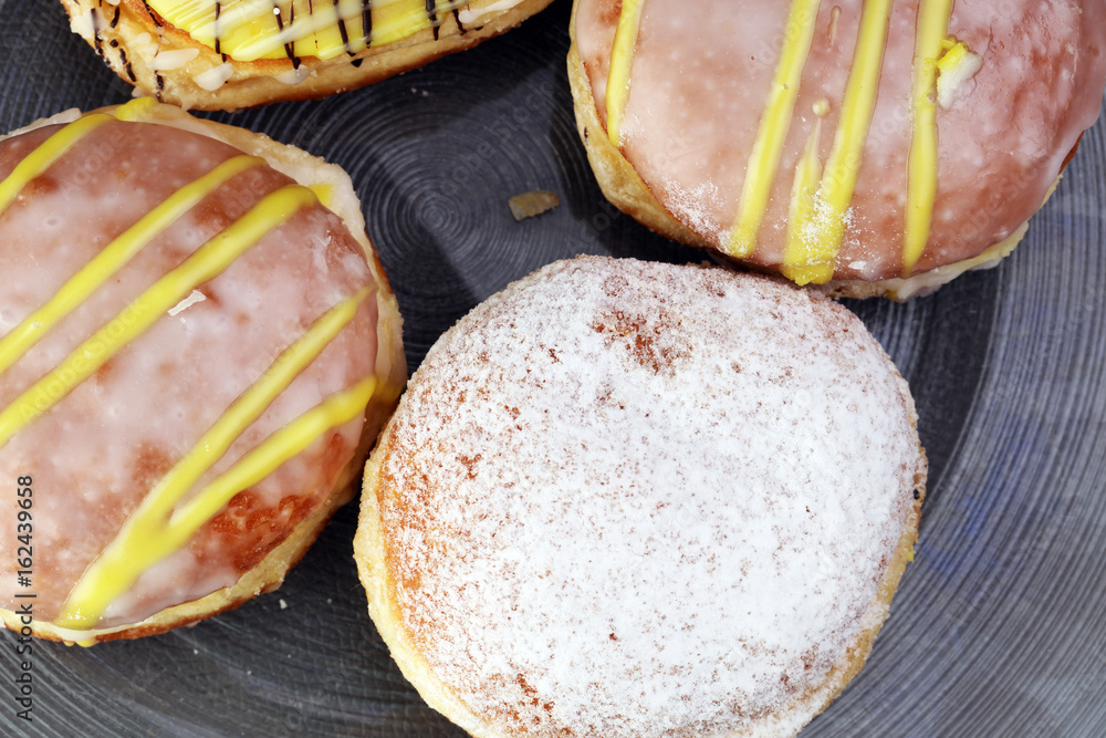 German donuts - berliner with jam and icing sugar in a tray on a grey ...