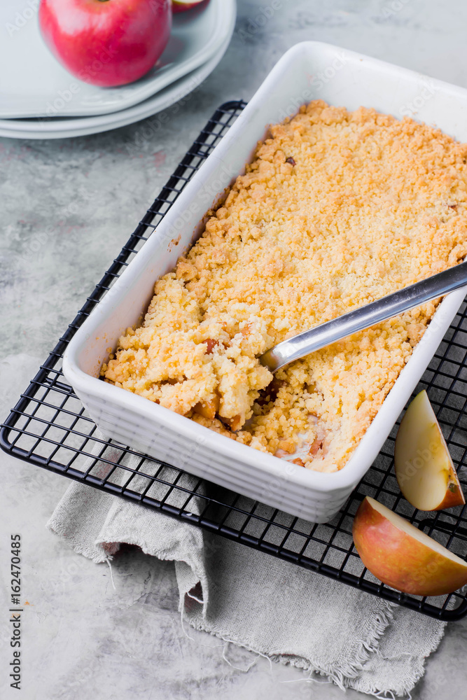 Apple crumble in white ceramic form on gray table background. Fruit pie ...