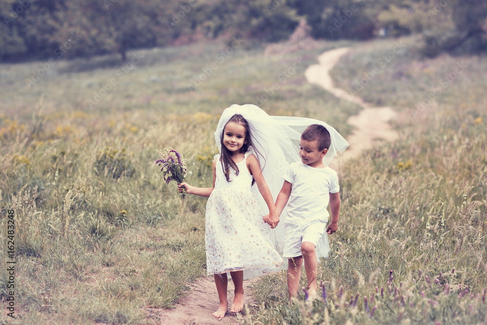 Young bride and groom playing wedding summer outdoor. Children like ...