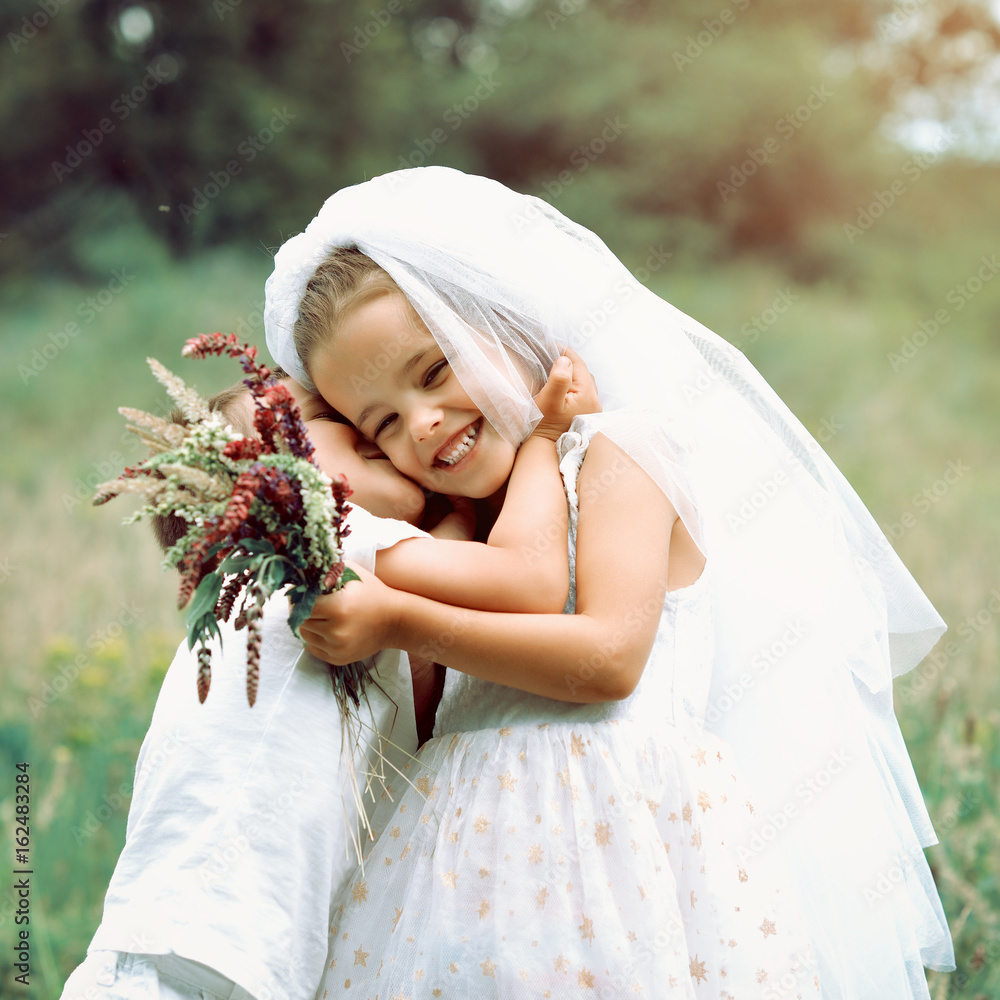 Young bride and groom playing wedding summer outdoor. Children like ...