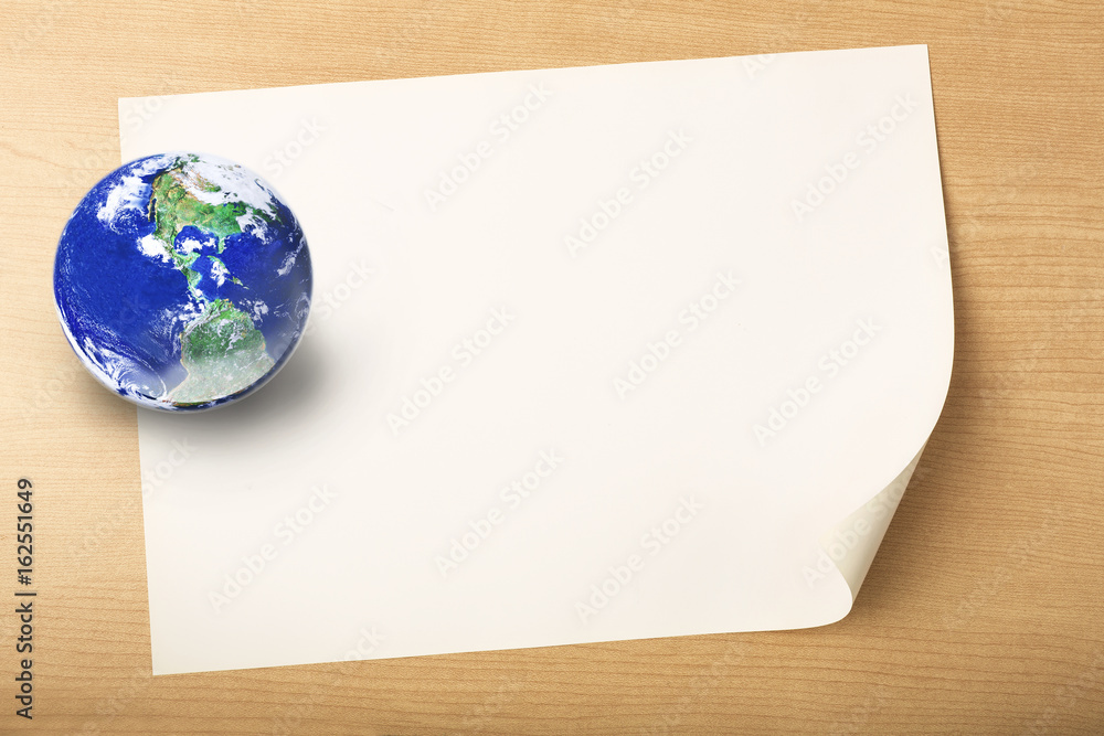 White paper with Earth on top with wood background, fill your ideas on ...