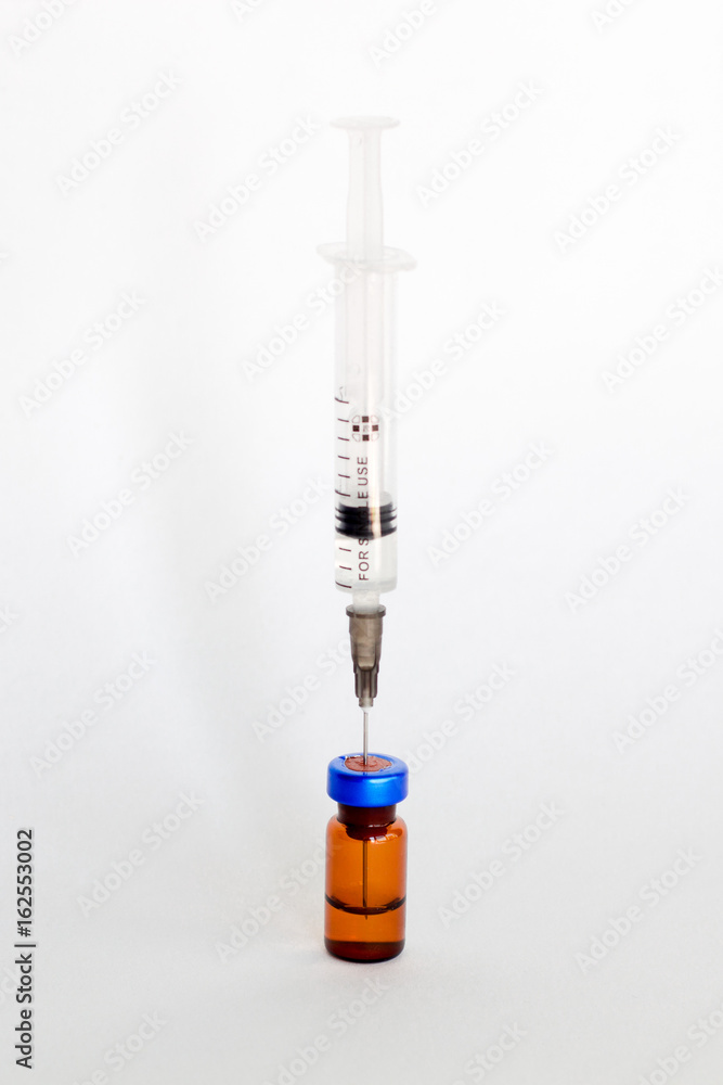 Medical vial, ampule for injection with a syringe on a white background ...