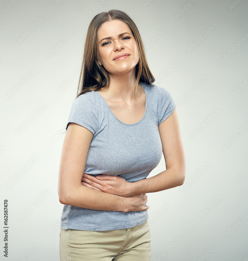 Woman with stomach pain touching tummy. Stock 写真 | Adobe Stock