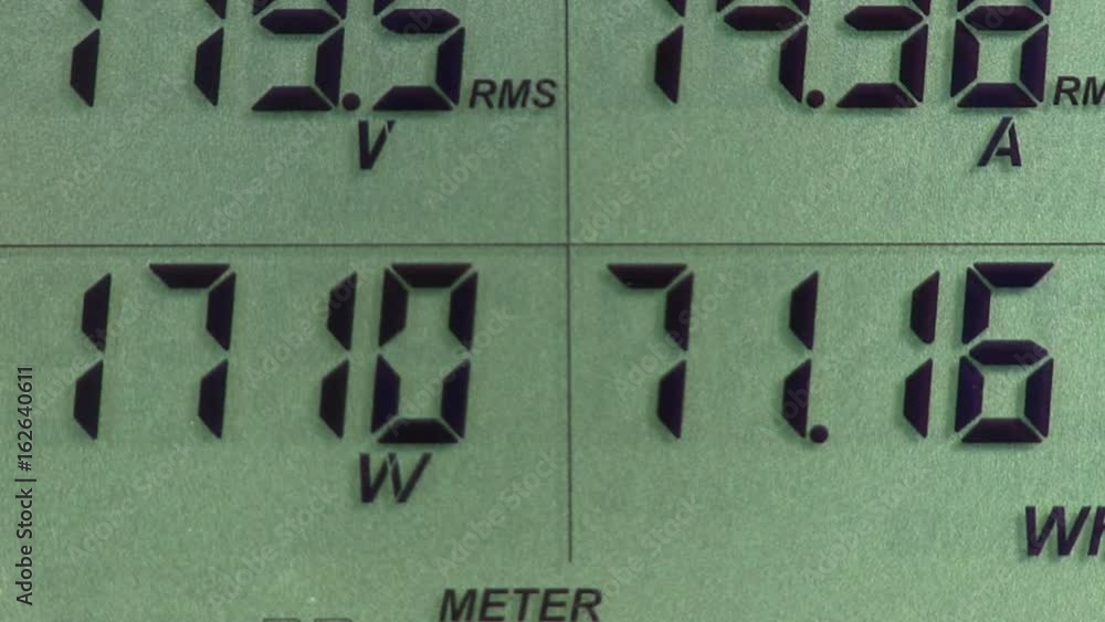 Slow pan from left to right of LCD display on digital power meter ...