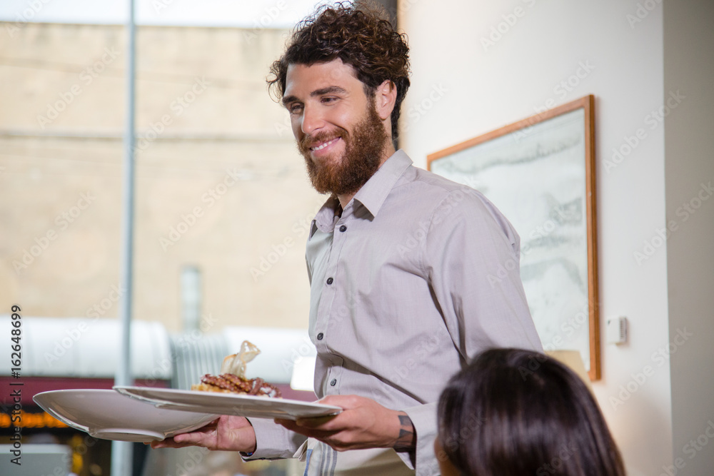 Happy waiter bringing out food smiling Stock Photo | Adobe Stock