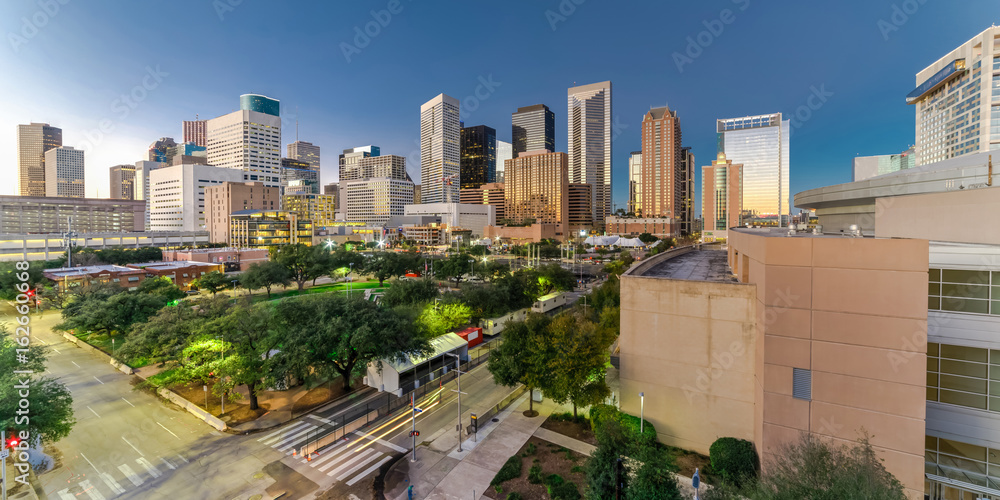 Aerial view downtown Houston illuminated at twilight with green city ...