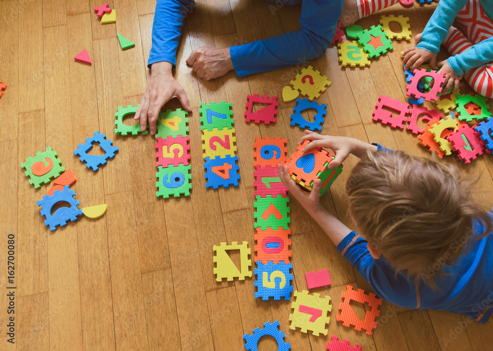 teacher and kids playing with number puzzle Stock Photo | Adobe Stock